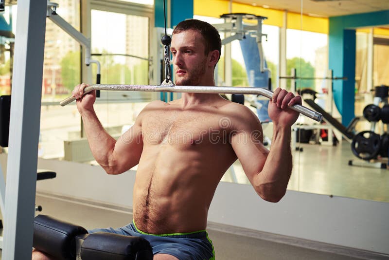 Man is Doing Shoulder Exercises on Cable Machine Stock Photo - Image of ...