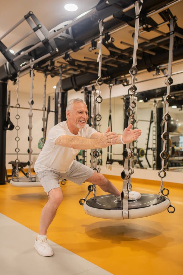 A Man Doing Squats on a Hanging Gym Machine and Smiling Stock Image ...