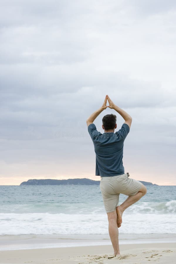 Man doing yoga on beach stock image. Image of relaxing - 4671859