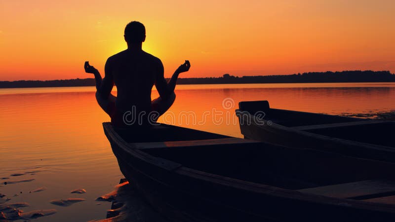 Man doing yoga at sunset stock image. Image of ocean - 163292233