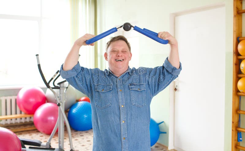 A Man with Down Syndrome Works Out with a Gym in the Gym. Stock Image ...