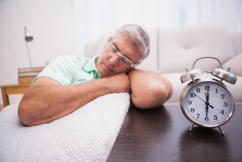 Man Dozing on the Couch beside Alarm Clock Stock Photo - Image of ...