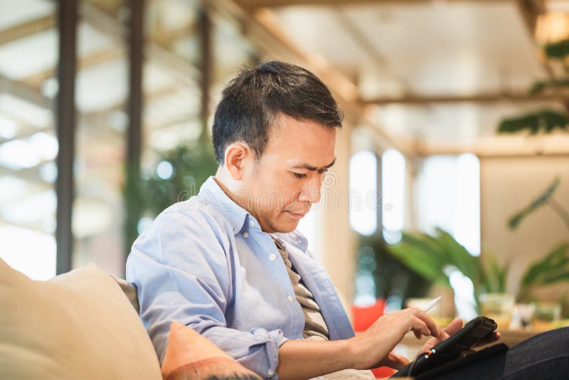 Man Drawing a Graphics on Tablet in a Modern Coffee Shop, Asian Man ...