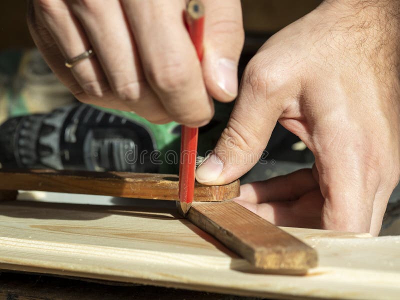 The Man Draws a Line with a Pencil on the Construction Board Measuring ...