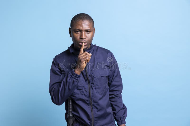Man Dressed in Security Agent Uniform Presents a Mute Gesture in Studio ...