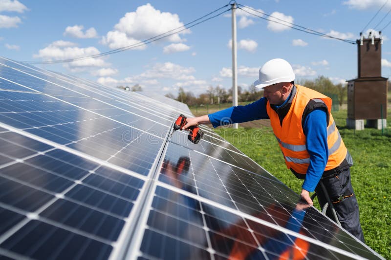 Man with Drill Screwdriver Installs Panels at a Solar Power Plant ...