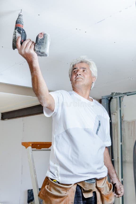 Man drilling ceiling stock photo. Image of project, handsome - 286824874