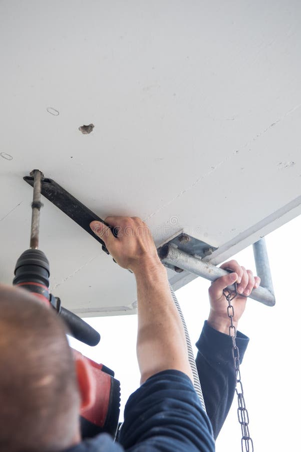 Man is Drilling Holes into Concrete Ceiling with Drilling Machine Stock ...