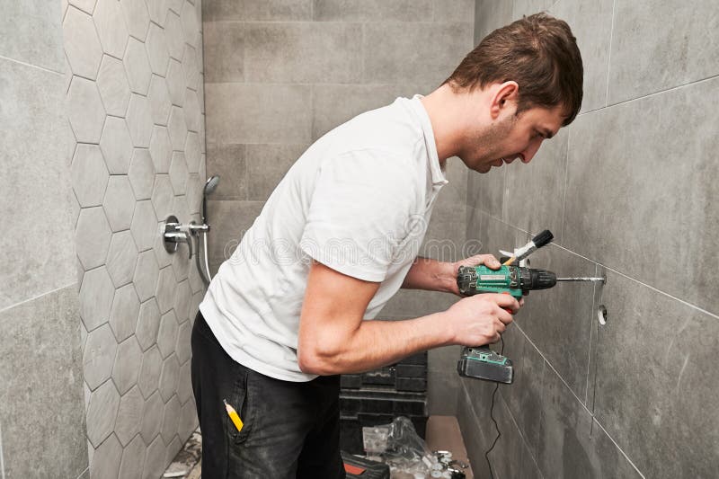 Man Drilling Wall with Electric Power Drill in Bathroom. Stock Photo ...