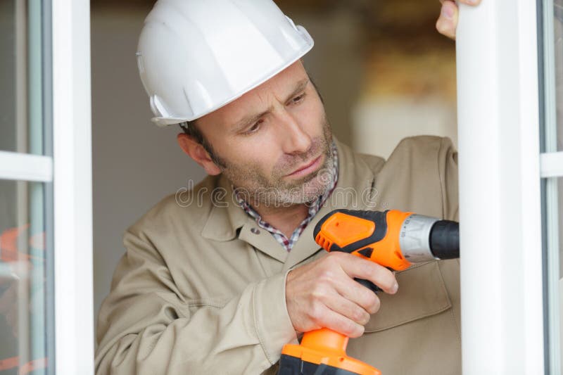 Man drills frame window stock photo. Image of hole, hand - 271543574
