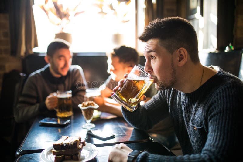 Man Drink Beer in Front of To Discussing Drinking Friends in Pub ...