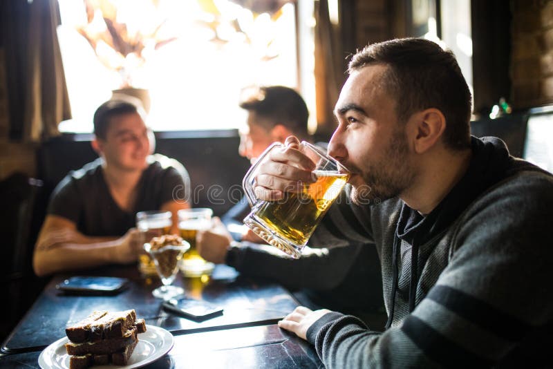 Man Drink Beer in Front of To Discussing Drinking Friends in Pub ...