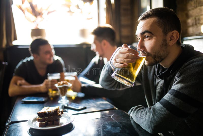 Man Drink Beer in Front of To Discussing Drinking Friends in Pub ...