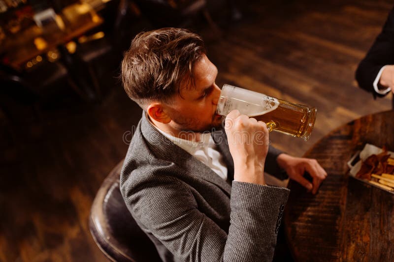 A Man Drinks Beer. Side View of Handsome Bald Man Drinking Beer in ...