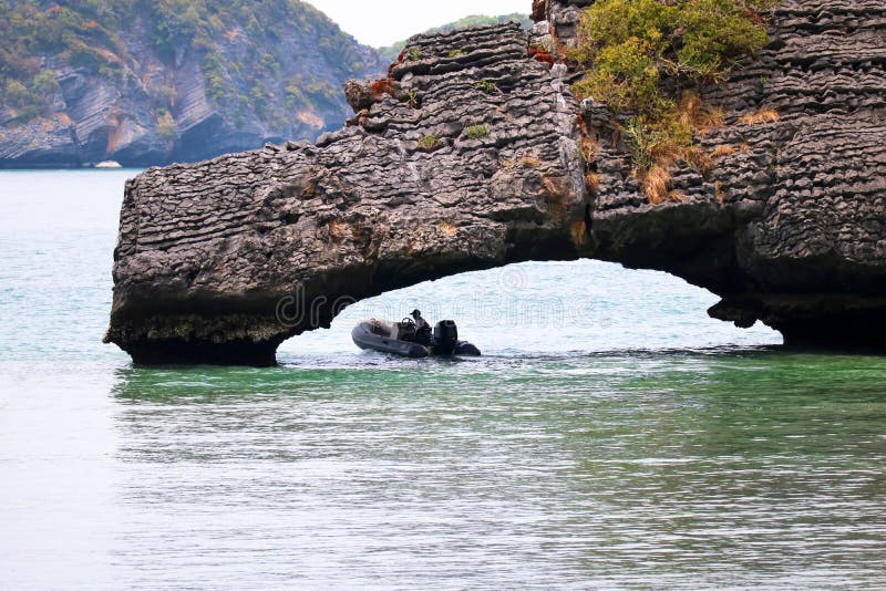 Man Driving a Boat Under a Stone. Stock Image - Image of coast, shore ...