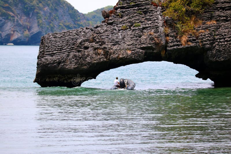 Man Driving a Boat Under a Stone. Stock Image - Image of destination ...