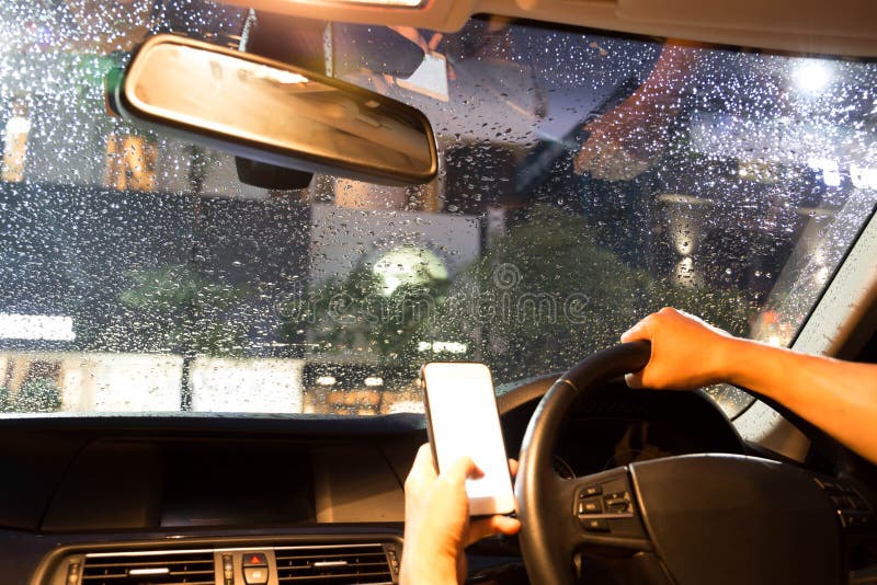 Man Driving Car and Using Cell Phone while Raining at Night Stock Photo ...