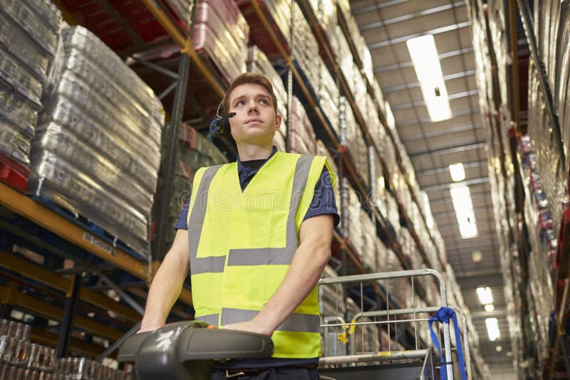 Man Driving a Tow Tractor in a Distribution Warehouse Stock Photo ...