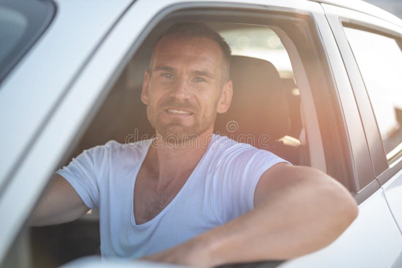 A man driving a white car. stock image. Image of open - 158647997