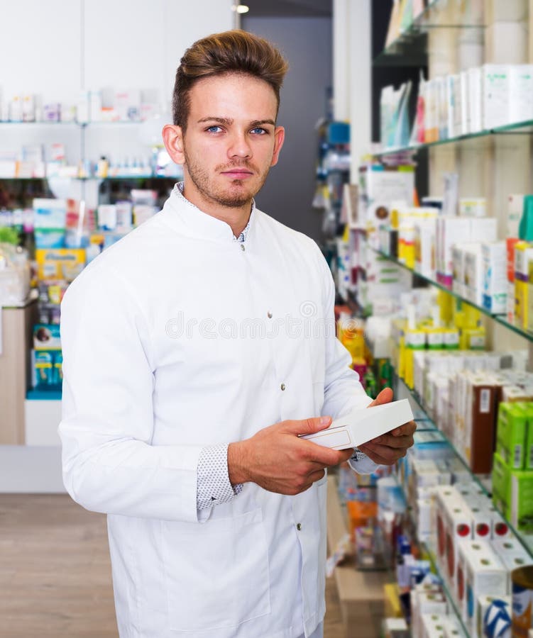 Man druggist in pharmacy stock photo. Image of shop - 218873702