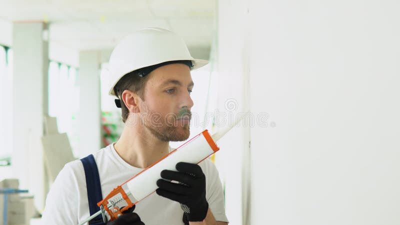 A Man Drywall Worker or Plasterer Sealing Seams of the Office Wall ...