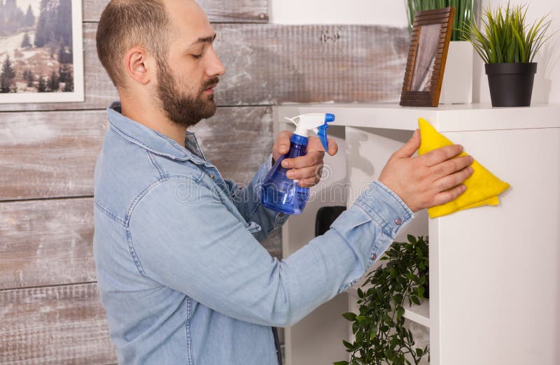 Man dusting the furniture stock image. Image of disinfect - 193038997