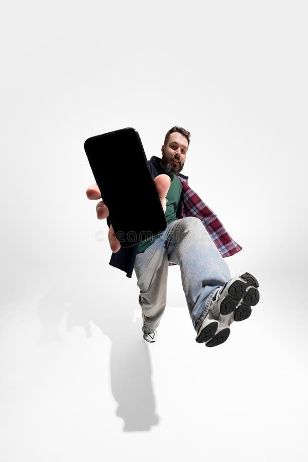 Man in Dynamic Pose with Smartphone with Black Screen To Viewer Against ...