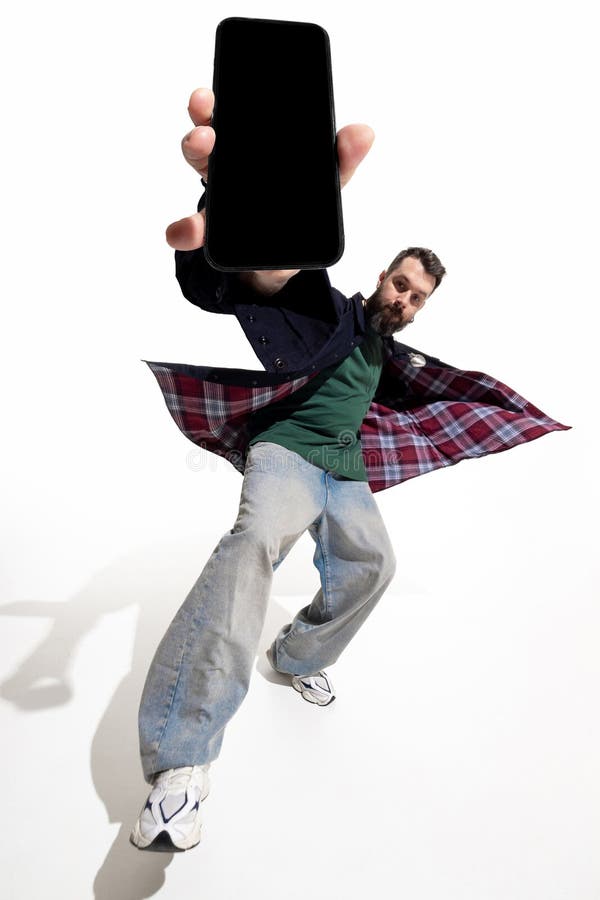 Man in Dynamic Pose Stretches Arm Forward with Smartphone with Blank ...