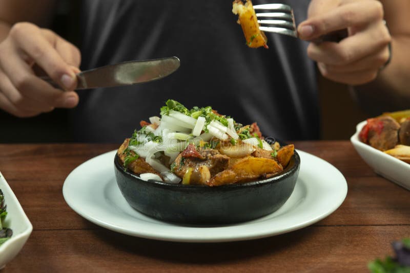 Man Eating Beef Stew with Potatoes, Carrots and Herbs on Black ...