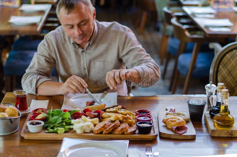 The Man is Eating Breakfast in the Restaurant. Stock Image - Image of ...