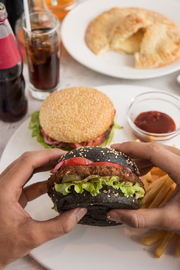 Man eating burgers stock image. Image of gourmet, fast - 99371479