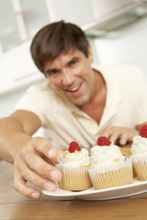 Man Eating Cakes in Kitchen Stock Photo - Image of cupcake, eating ...