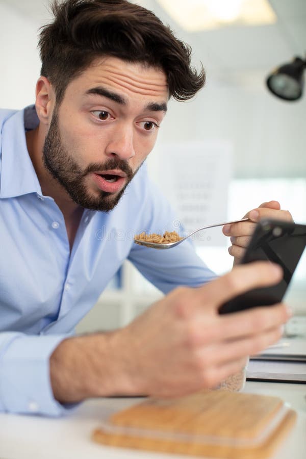 Man Eating Cereal Surprised by Content on Smartphone Stock Image ...