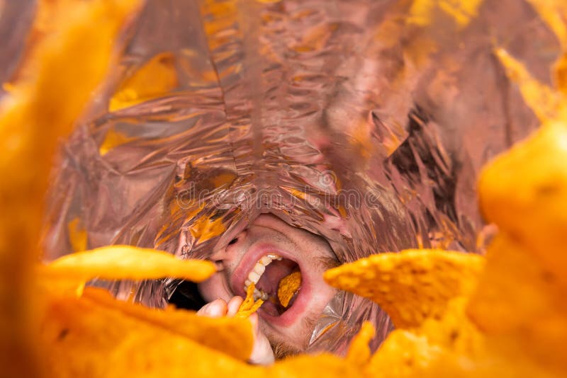 Man Eating Chips, Camera in a Package with Nachos. Looks Inside Stock ...