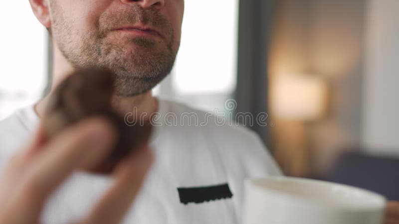 Man Eating Eating Chocolate Muffin and Drinking Tea. Close-up Stock ...