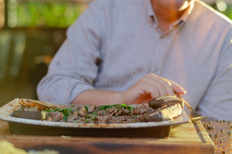The Man is Eating Meat at Dinner. Stock Photo - Image of restaurant ...