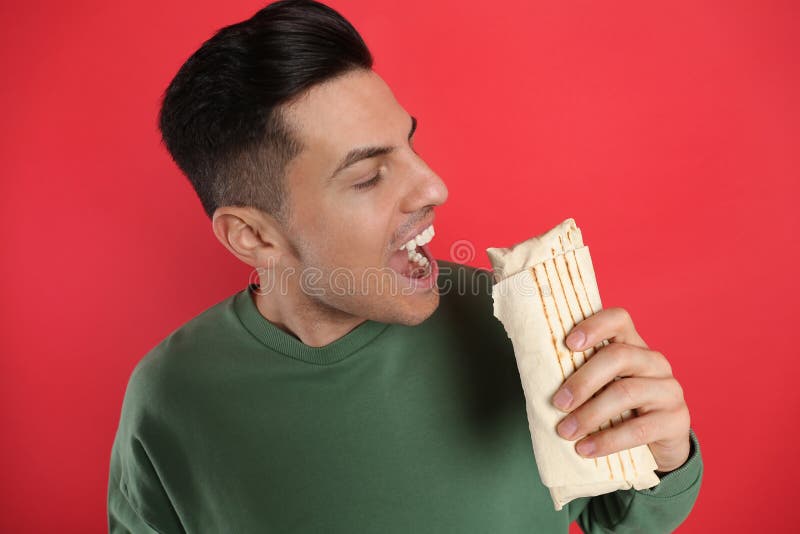 Man Eating Delicious Shawarma on Red Background Stock Photo - Image of ...