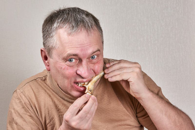 Man Eating Fried Smelt Fish Holding Fish with Hands in Front of Face ...
