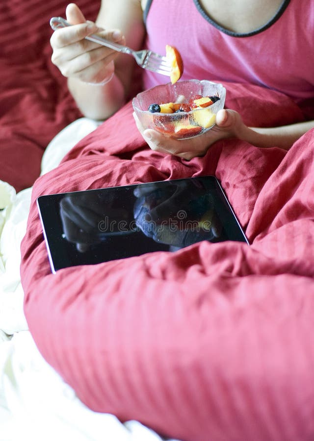 Man Eating Fruit and Using Tablet Computer Stock Photo - Image of bowl ...
