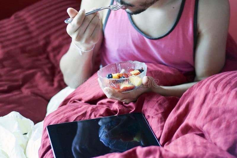 Man Eating Fruit and Using Tablet Computer Stock Photo - Image of bowl ...