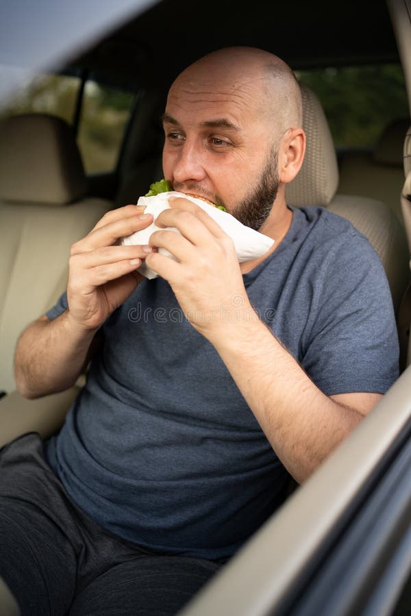 Man Eating Hamburger in Car while Taking Lunch Break Stock Image ...