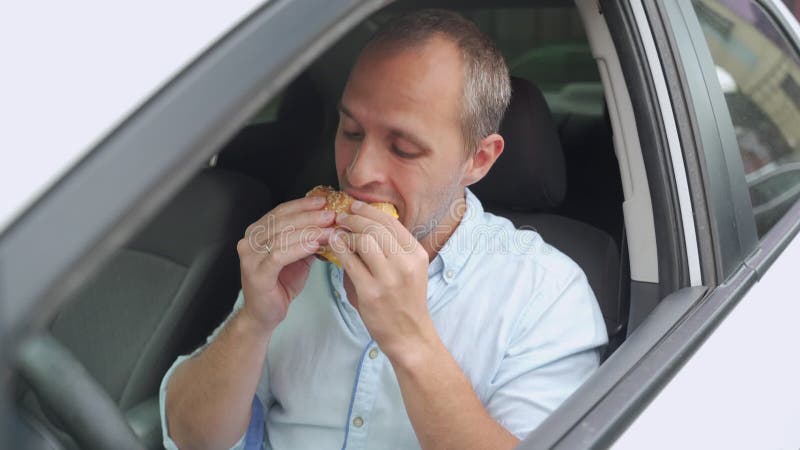 Man Eating an Hamburger while Driving His Car Stock Footage - Video of ...