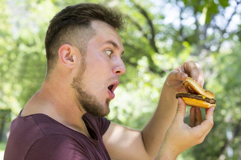 Man eating a hamburger stock image. Image of lunch, emotional - 76043381