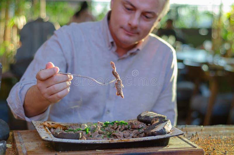 The Man is Eating Meat at Dinner. Stock Image - Image of meat, male ...