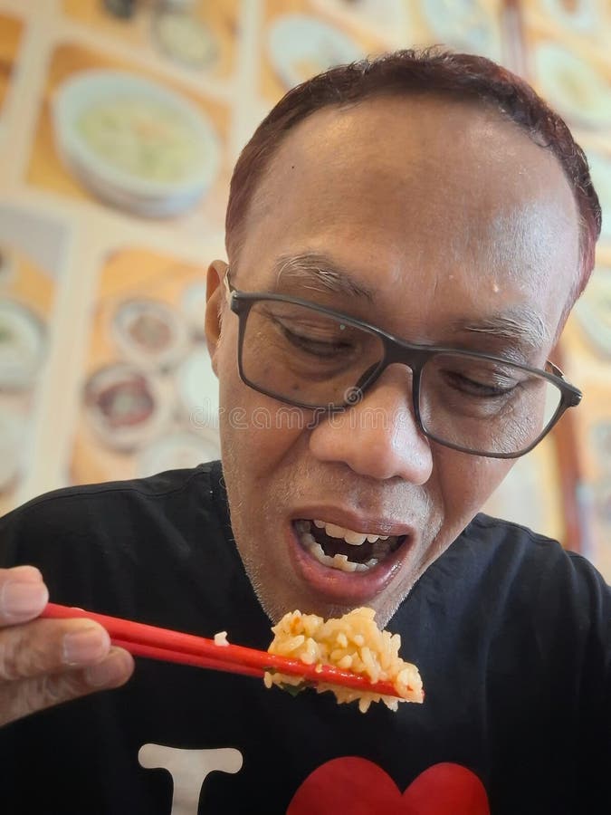 A Man Eating Rice with Chopsticks in a Chinese Restaurant Stock Photo ...