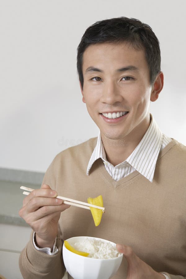 Man Eating Rice and Peppers with Chopsticks Stock Photo - Image of ...