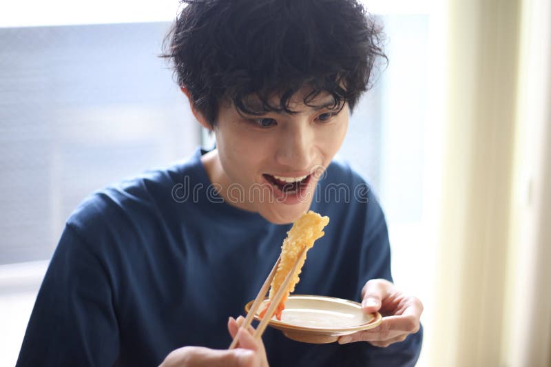 Man eating shrimp tempura stock photo. Image of food - 325339400