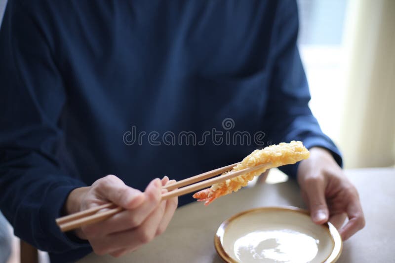 Man eating shrimp tempura stock image. Image of tempura - 325339403