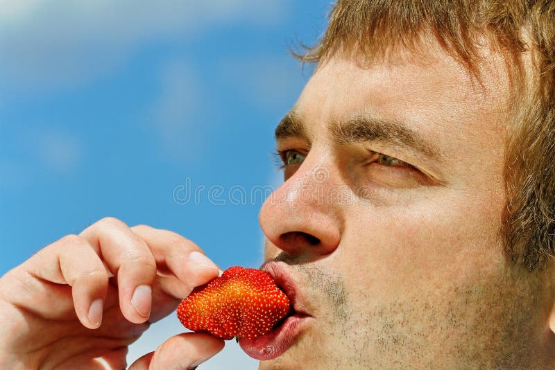 Man eating strawberry. stock photo. Image of cloud, beautiful - 25335394