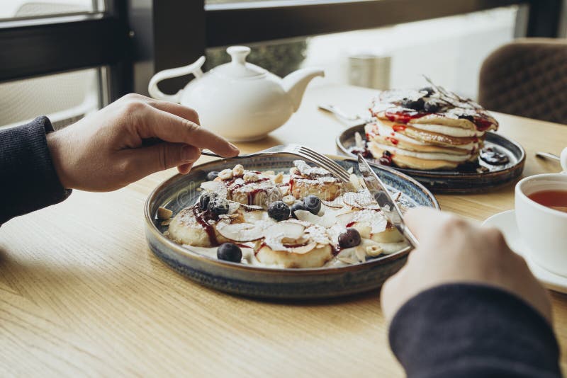 A Man Eats Cheesecakes in a Cafe for Breakfast, a Traditional Ukrainian ...